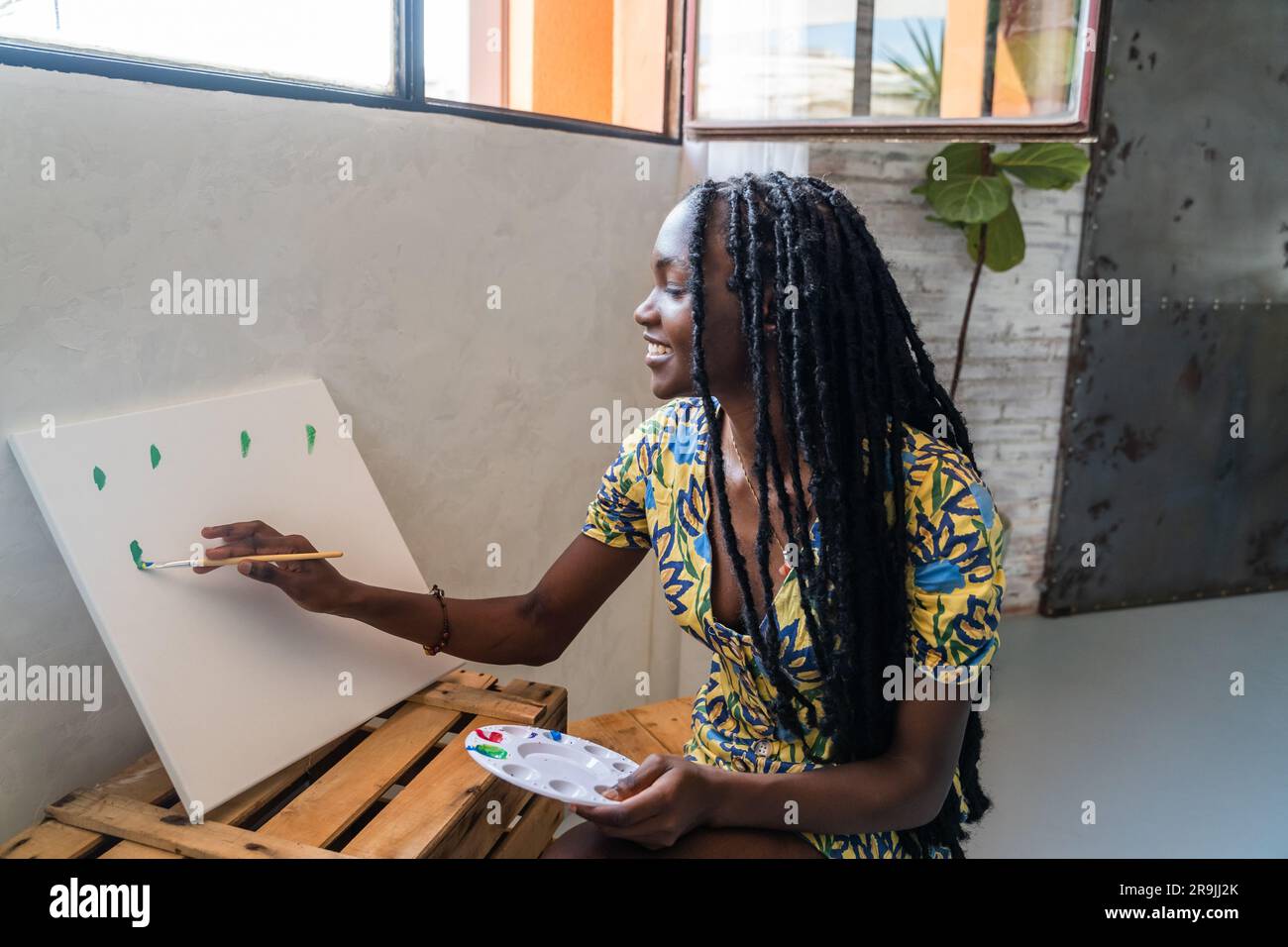 Positive young African American female artist in casual clothes with ...