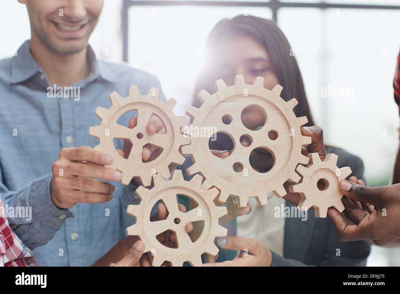 Office worker holding cog wheel as unity and teamwork in corporate ...