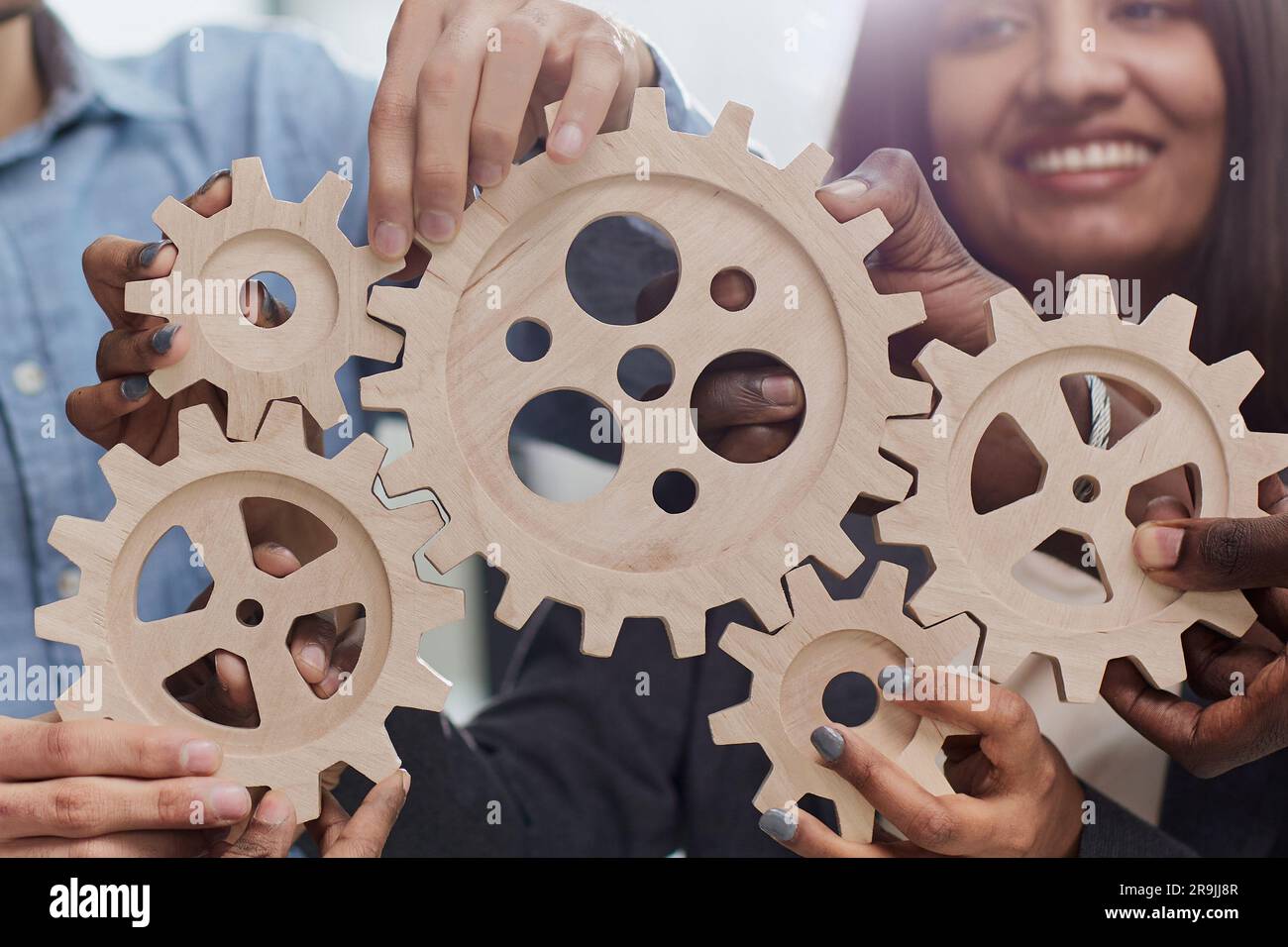 Office worker holding cog wheel as unity and teamwork in corporate ...