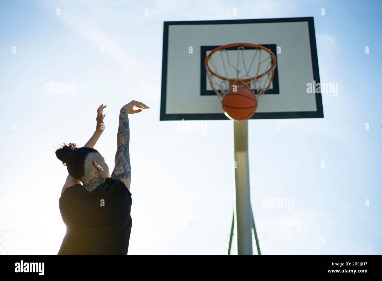 From below back view of anonymous female basketball player throwing ...