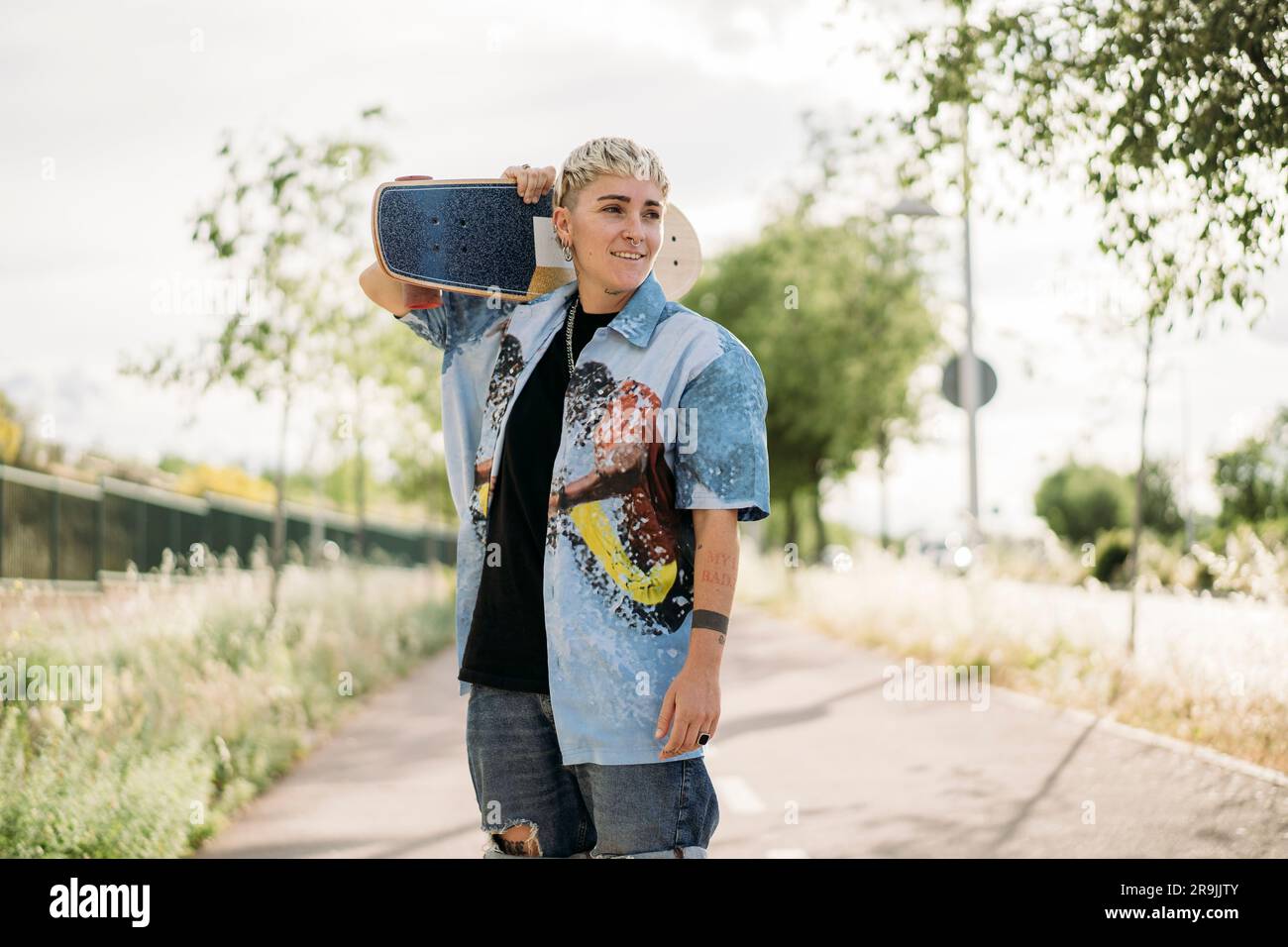 Positive shy young female in casual tomboy outfit holding with with the ...