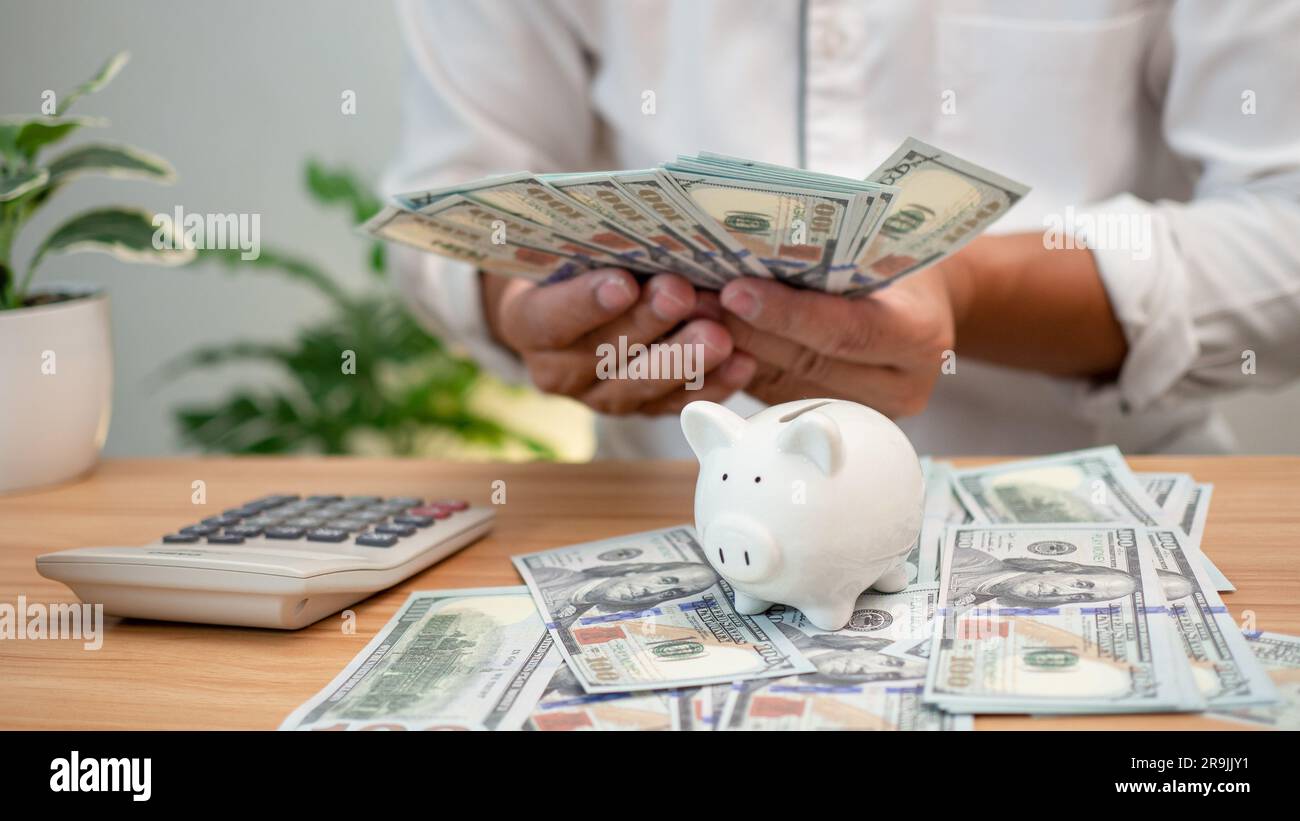 Woman counting calculator and putting coins in piggy bank close up ...