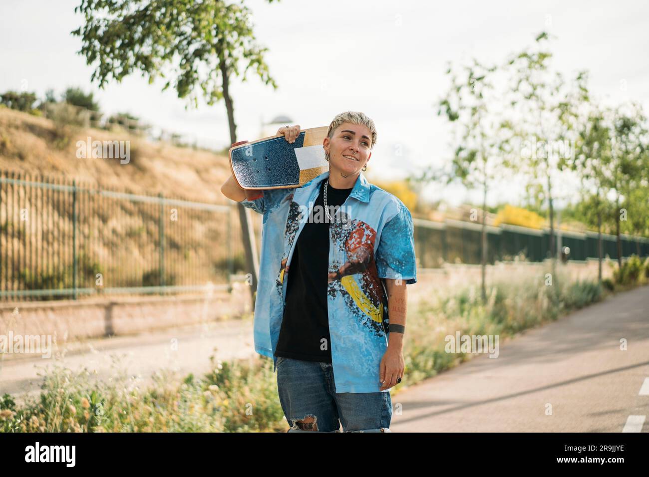 Positive shy young female in casual tomboy outfit holding with with the ...