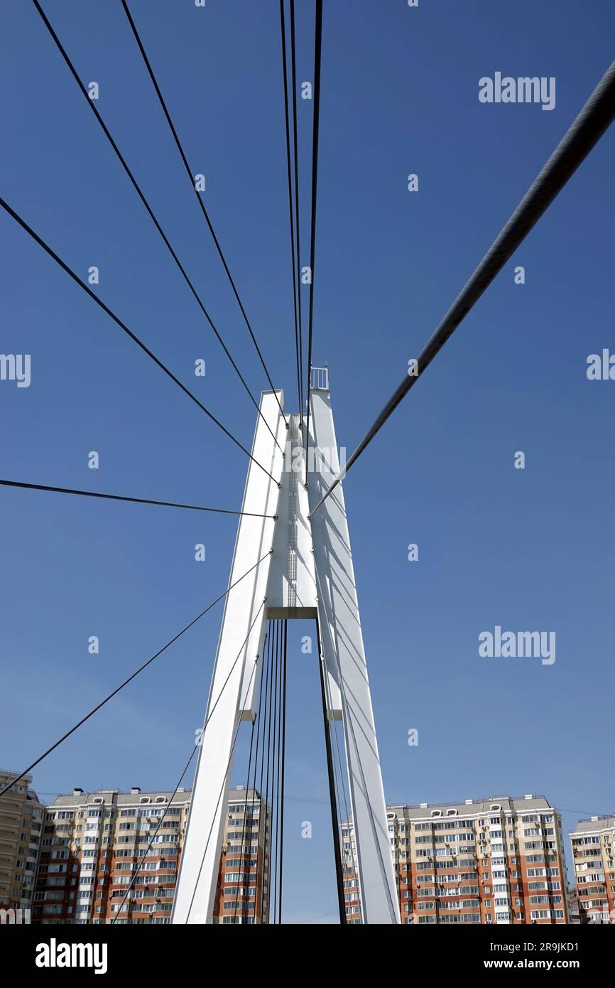 Modern urban cable-stayed bridge with metal ropes in the city district ...
