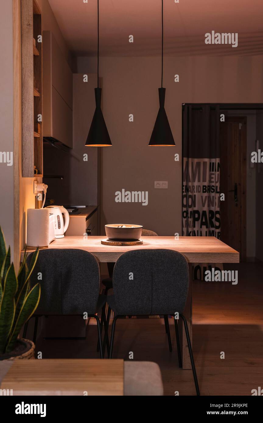 Minimalist kitchen interior design with dining area with orange lights ...