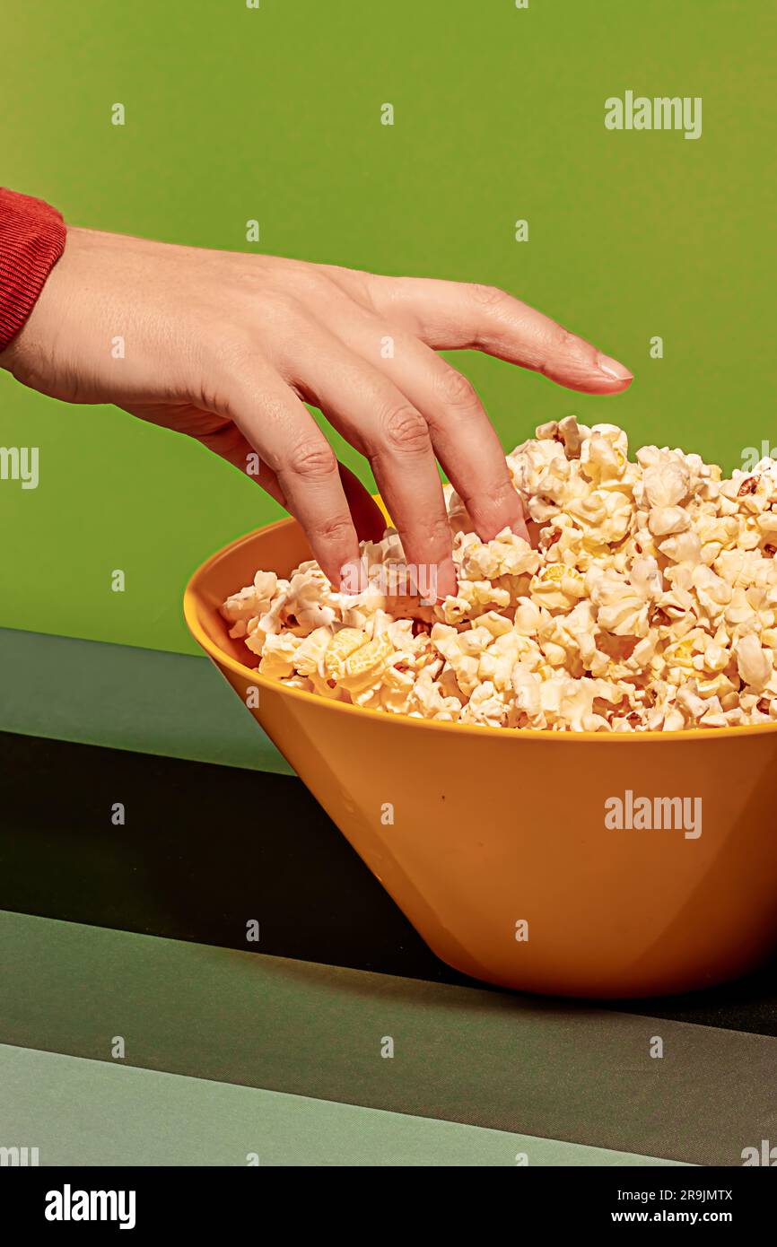 Crop anonymous female with hand picking delicious popcorn heap in ...