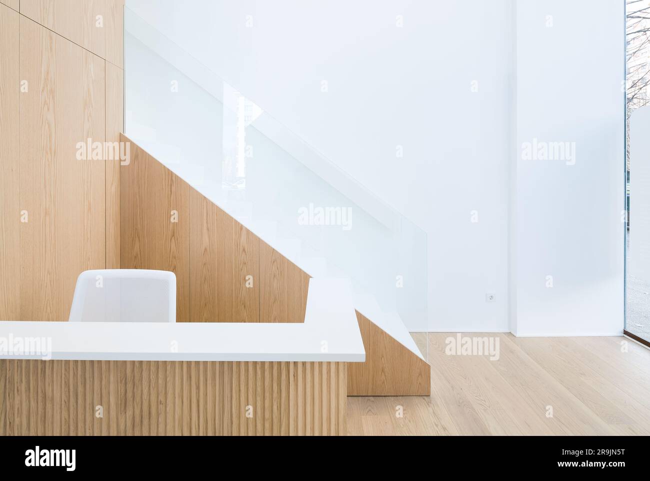 Interior design of illuminated reception desk near white staircase and ...