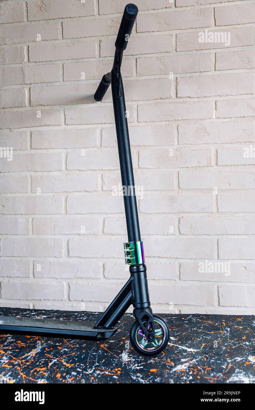 The front wheel of a rainbow-colored stunt scooter or a durable ...