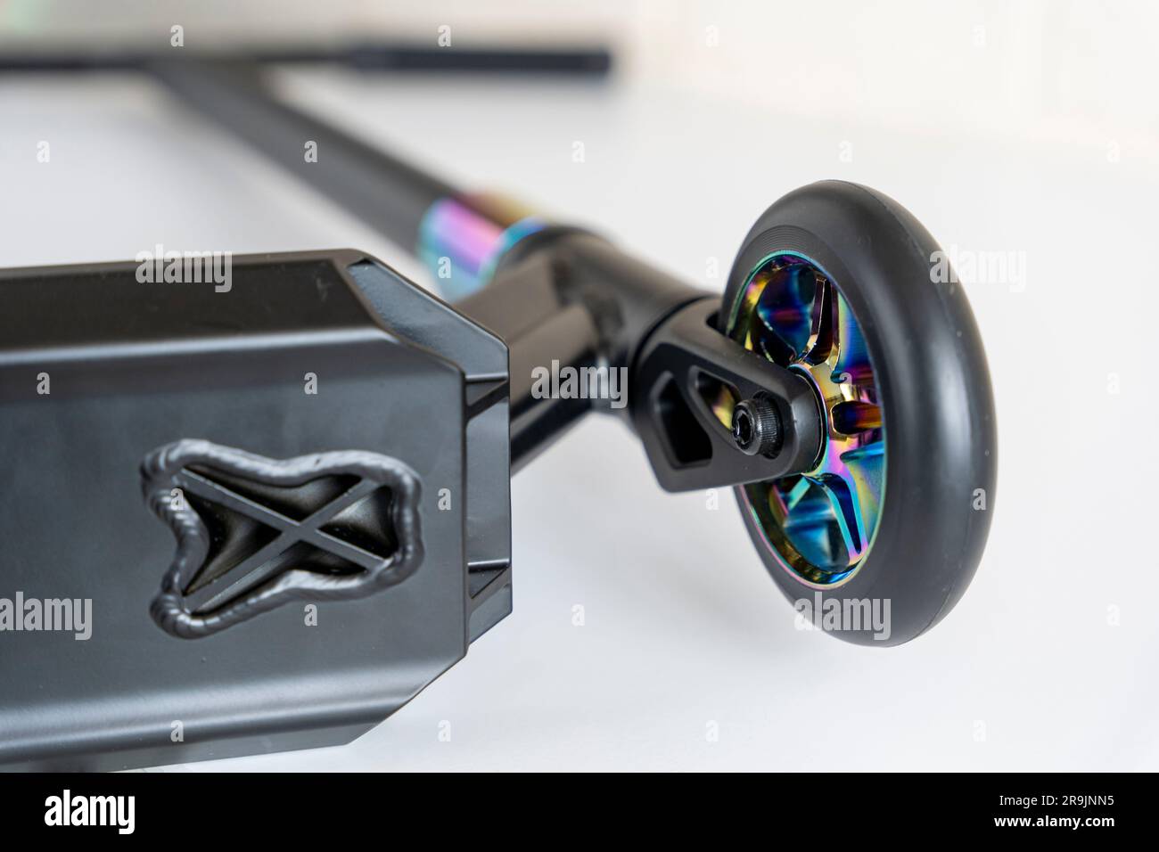 A stunt scooter with rainbow-colored wheels. Bottom view of the ...