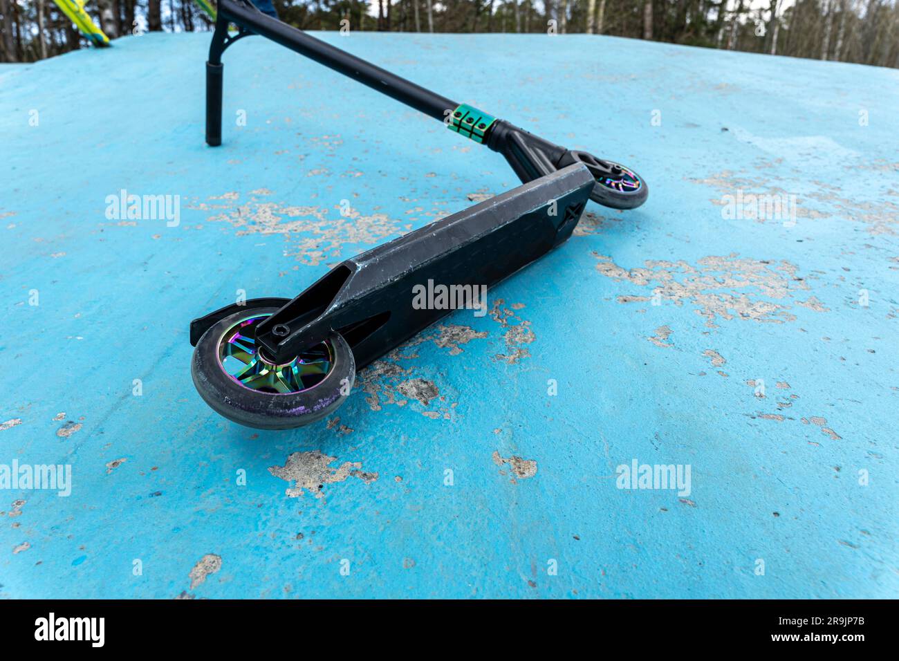 a stunt scooter, a modern extreme stunt scooter in a skate park lies on ...