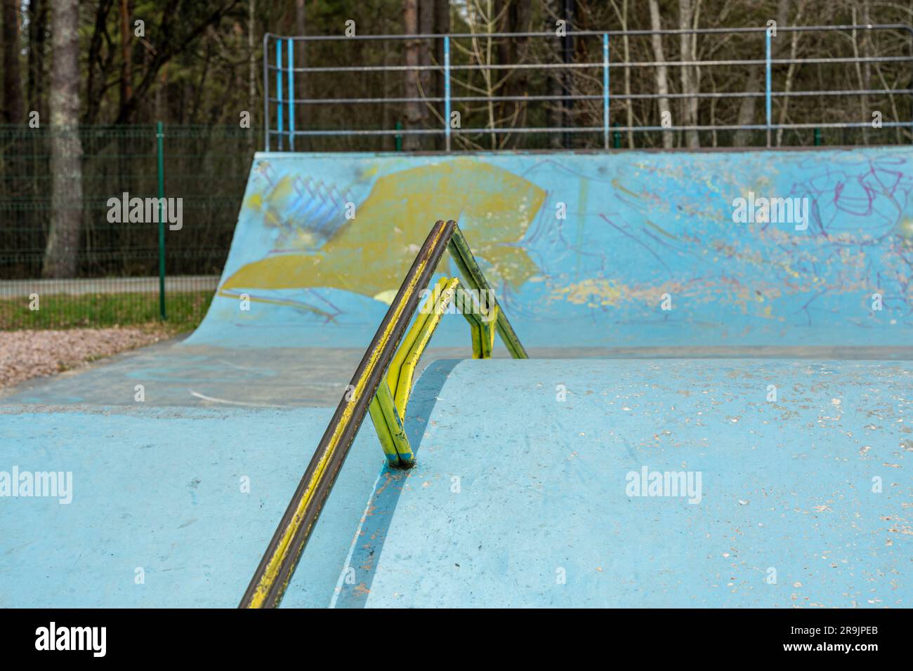 a ramp with an iron ramp for jumping in a skate park. concrete ramp for ...