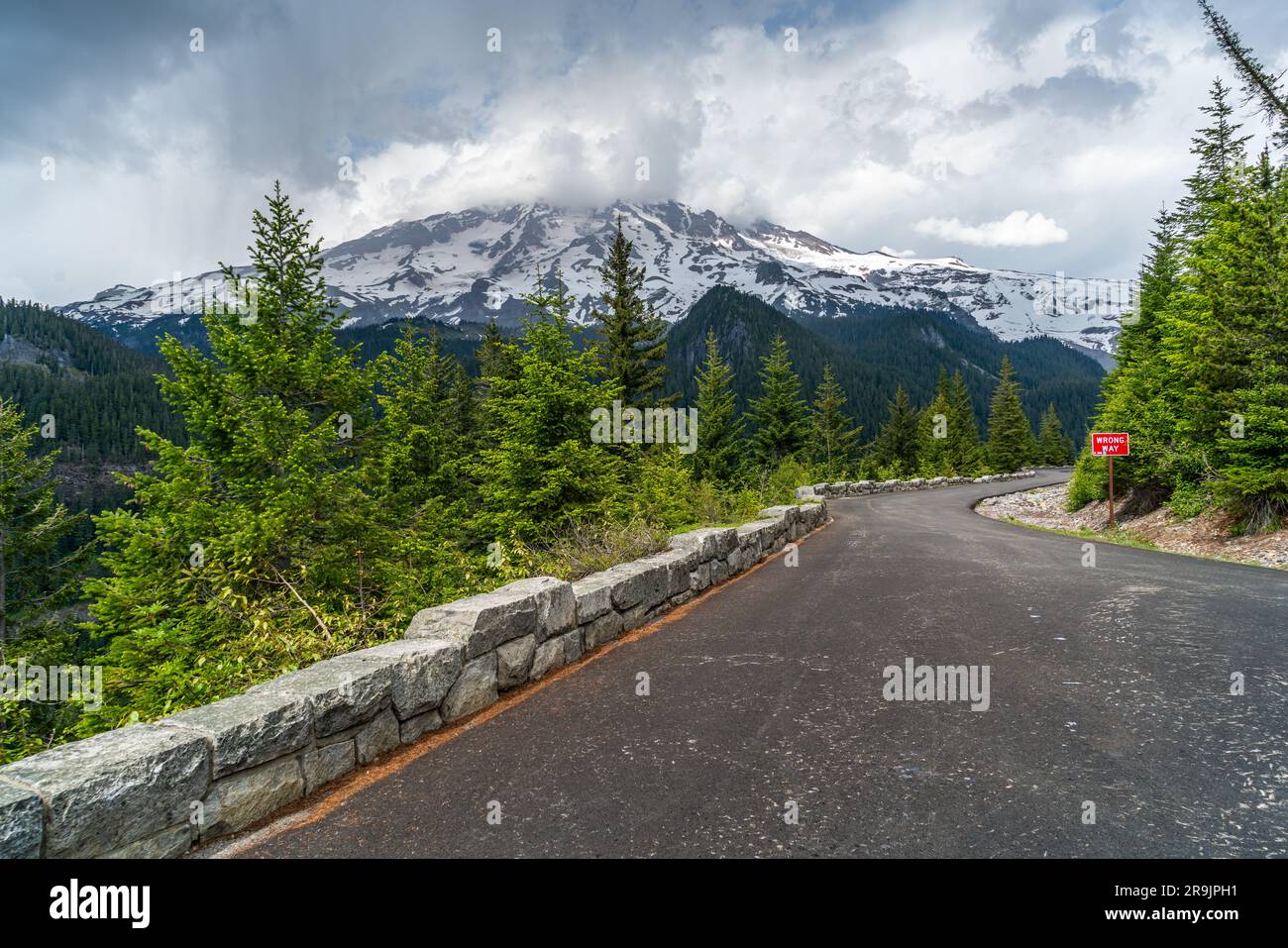 A view of a road and Mount Rainier with clouds in Washington State ...