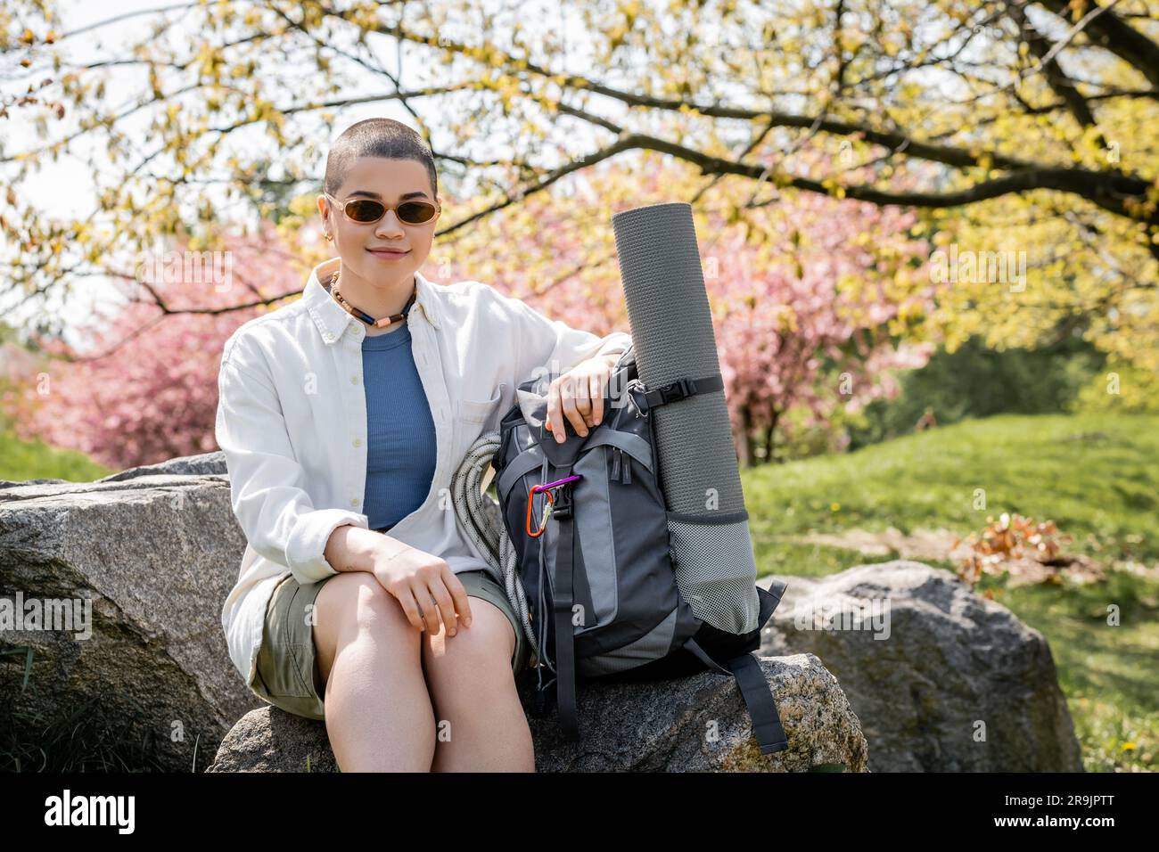 Positive short haired and young female hiker in casual clothes and ...
