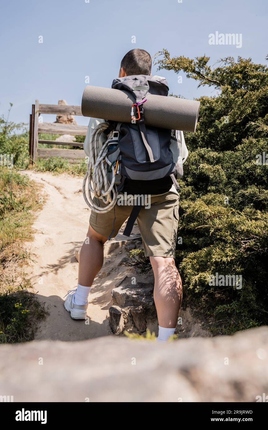 Back view of young and short haired woman tourist in casual clothes ...