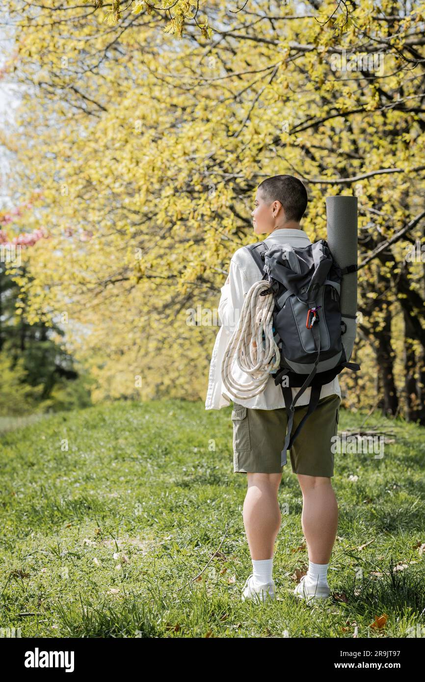 Side view of young and short haired female tourist with backpack ...