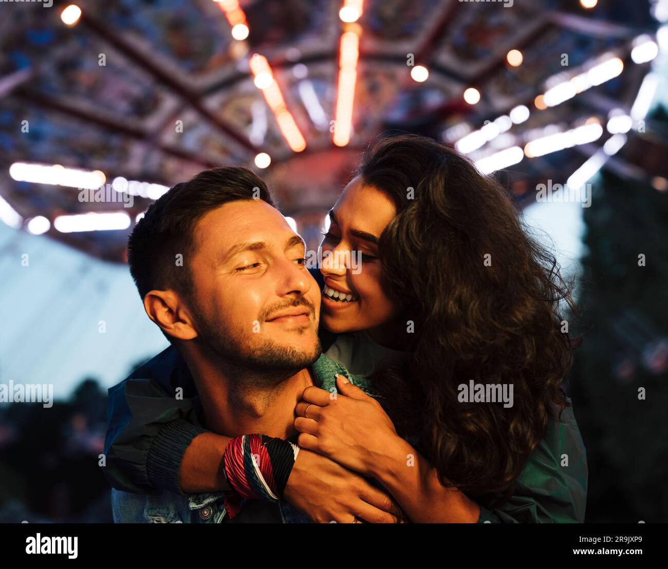 Young couple having fun ant night in amusement park Stock Photo - Alamy