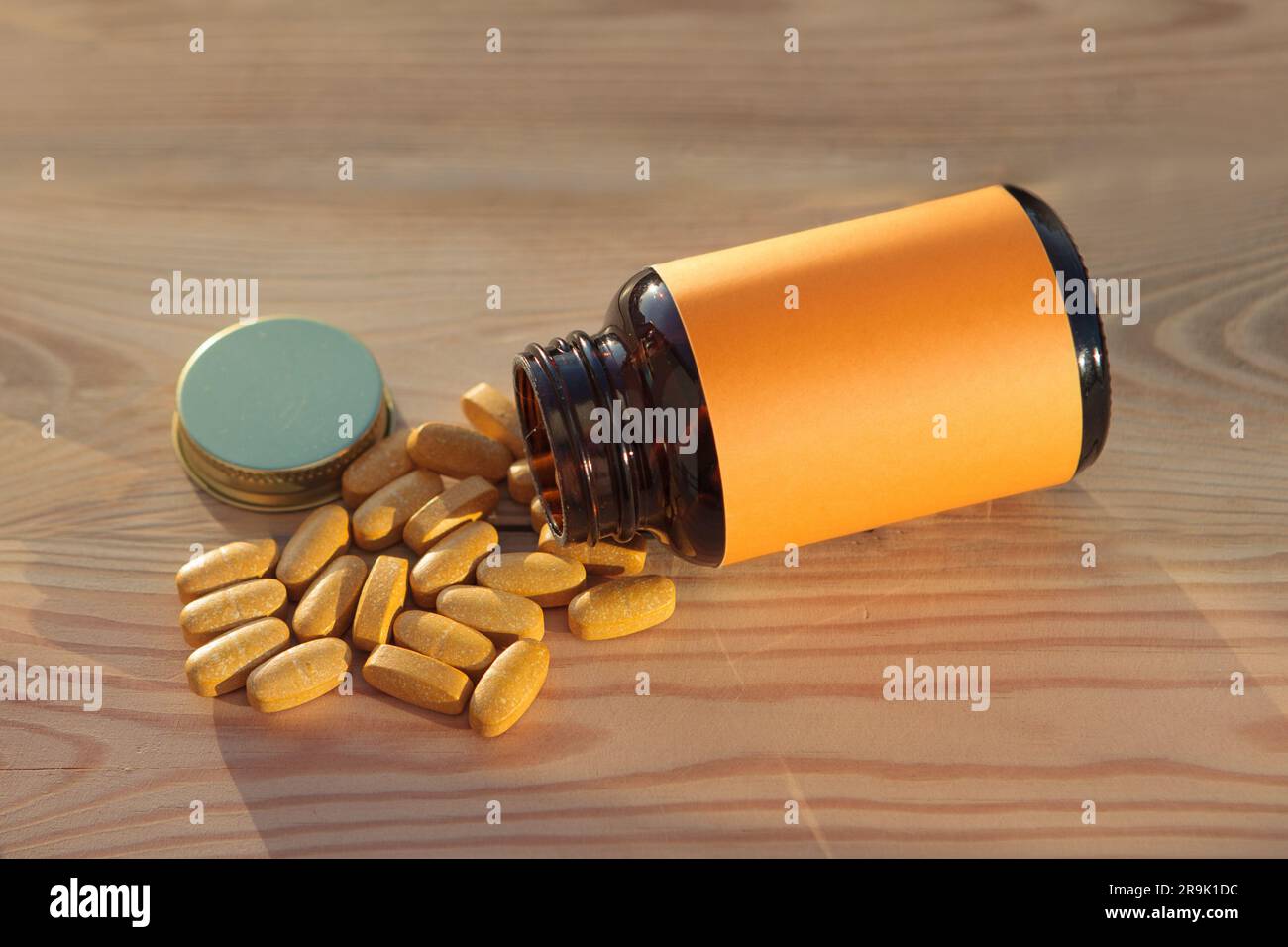 Orange pills scattered on a wooden tabletop, Natural medicines, concept ...