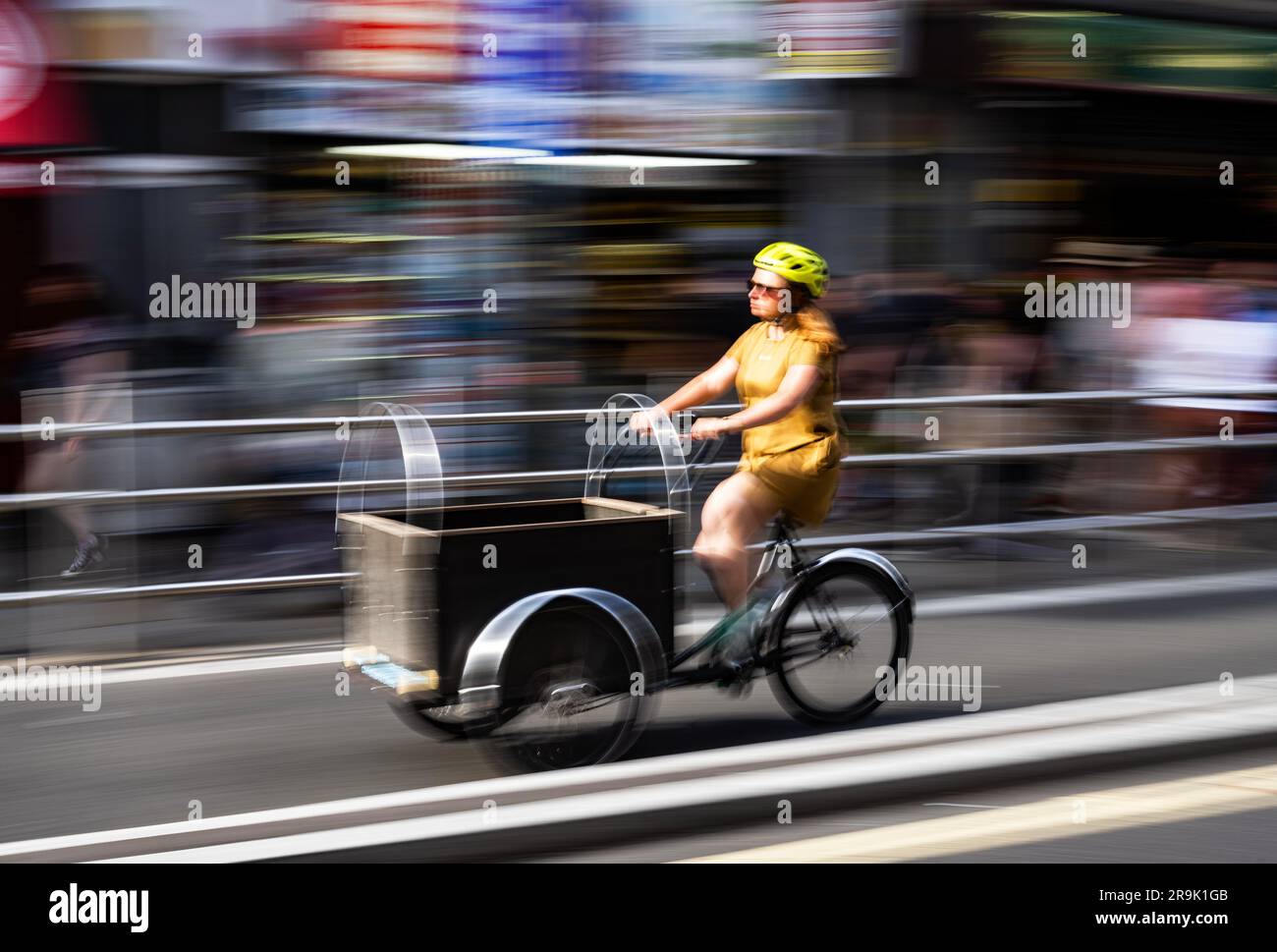 Woman on bike with pannier in front moving at speed in King St in ...