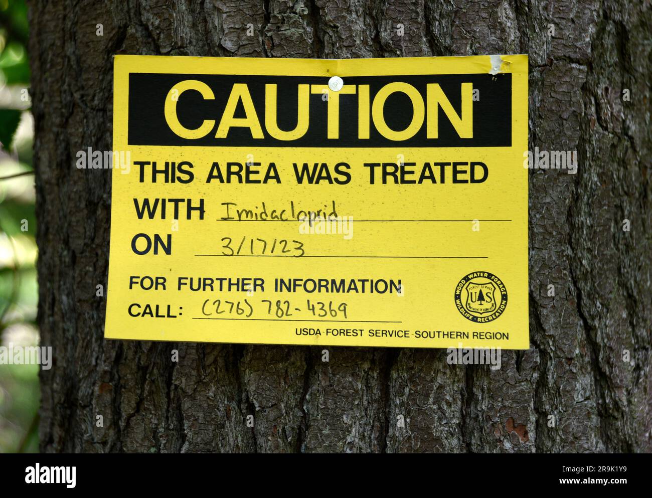 A caution sign posted on a tree in a US national forest warns visitors ...