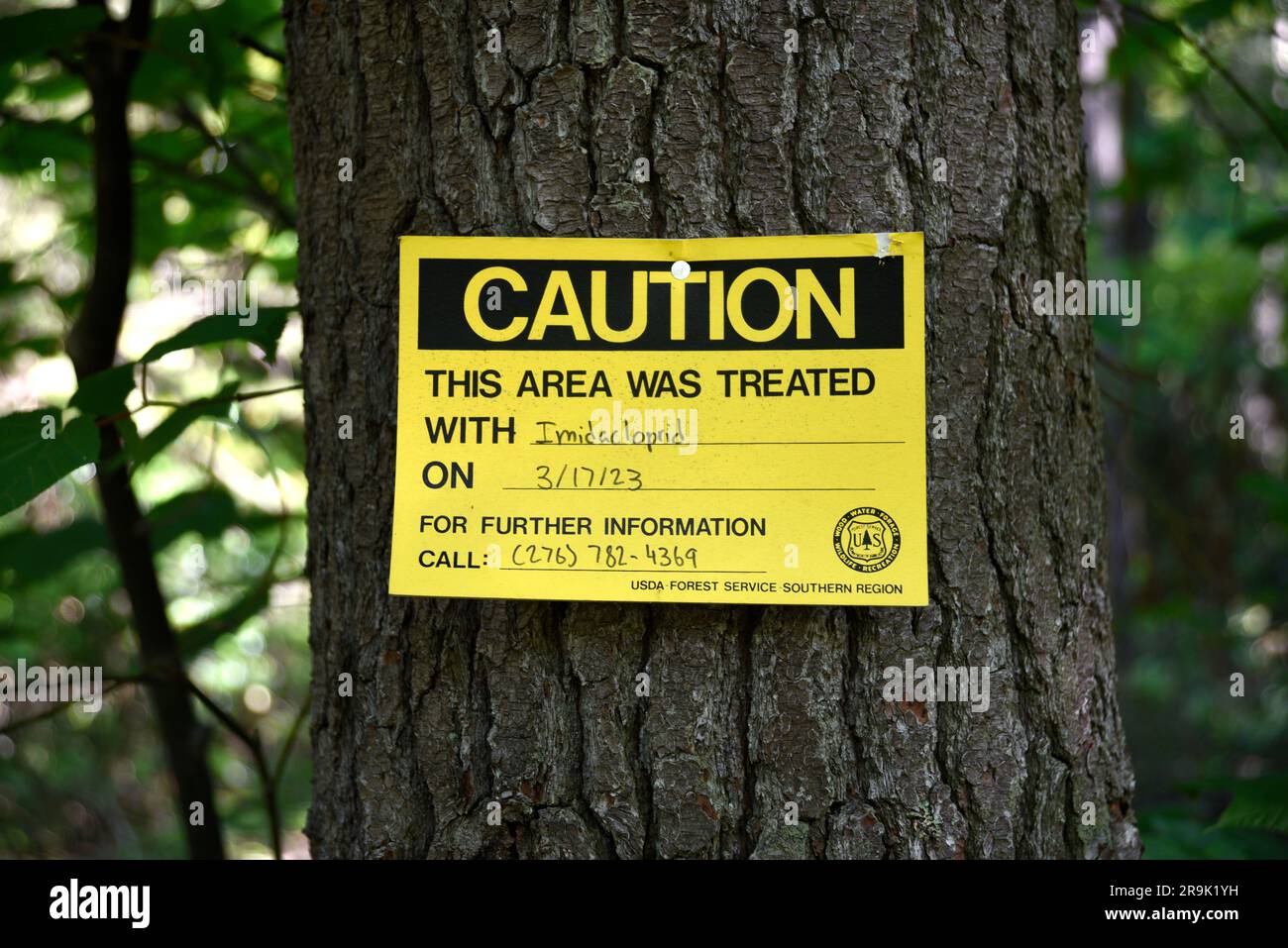 A caution sign posted on a tree in a US national forest warns visitors ...