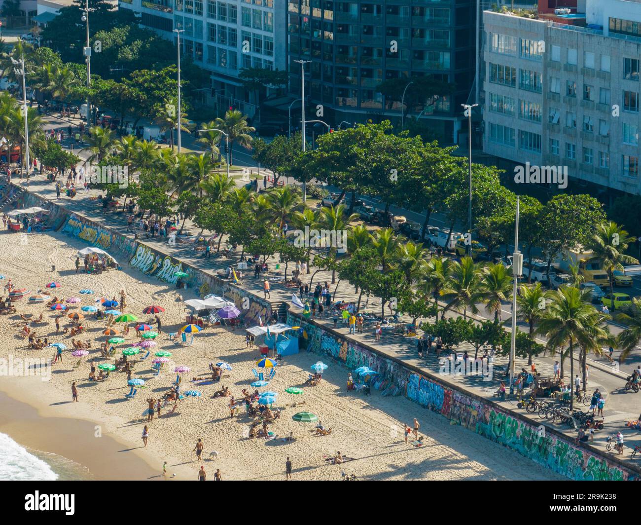 Aerial view of Ipanema beach. People sunbathing and playing on the beach, sea sports. Rio de ...