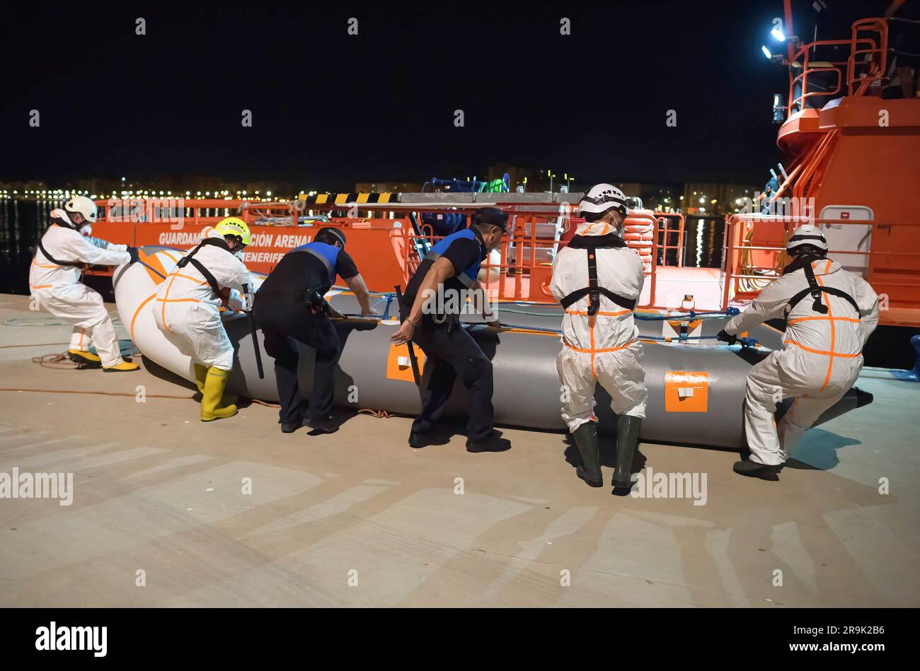 Rescue workers and police port are seen moving the dinghy used by ...