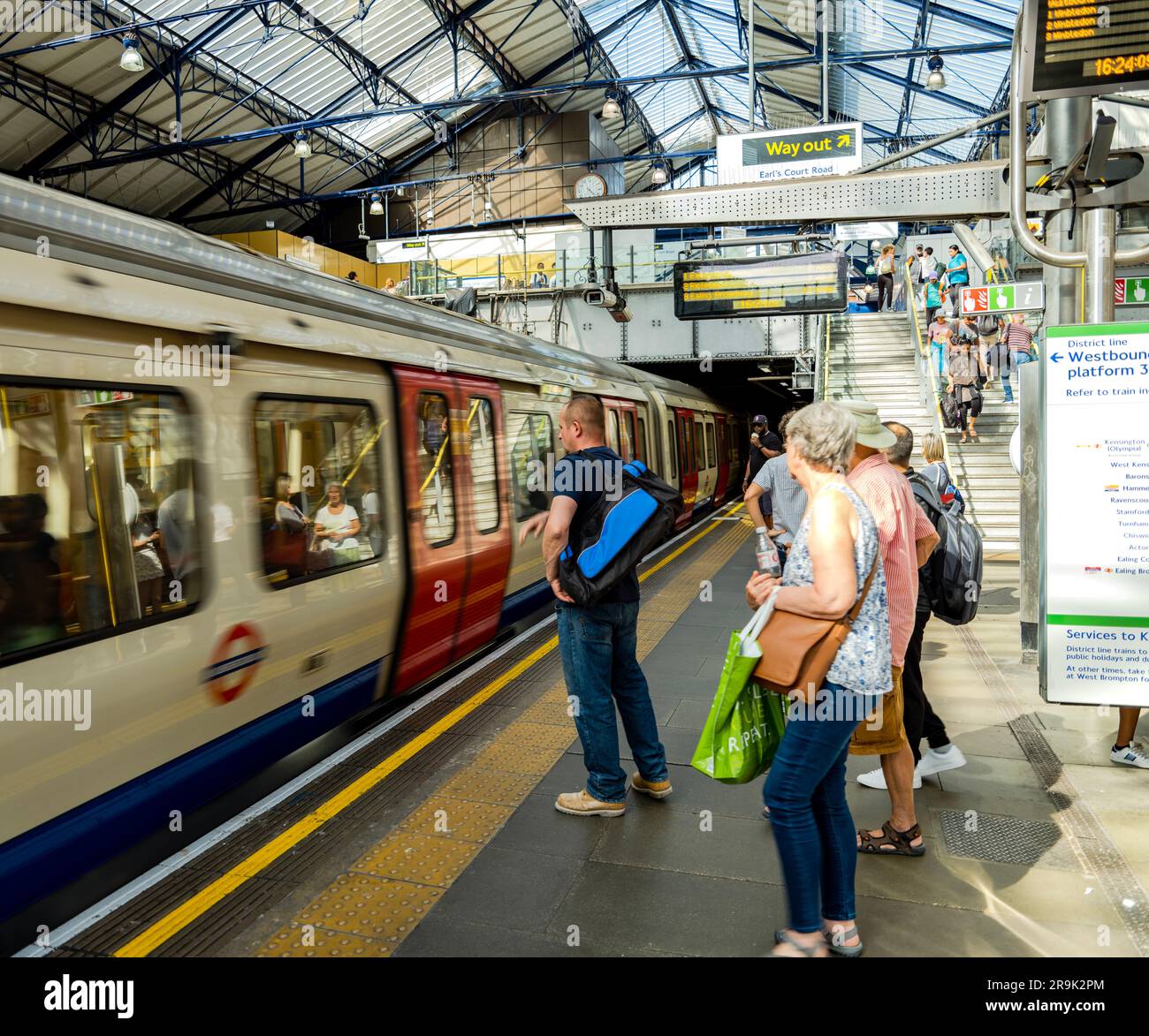 Commuters on Earls Court Underground station waiting as a District Line ...