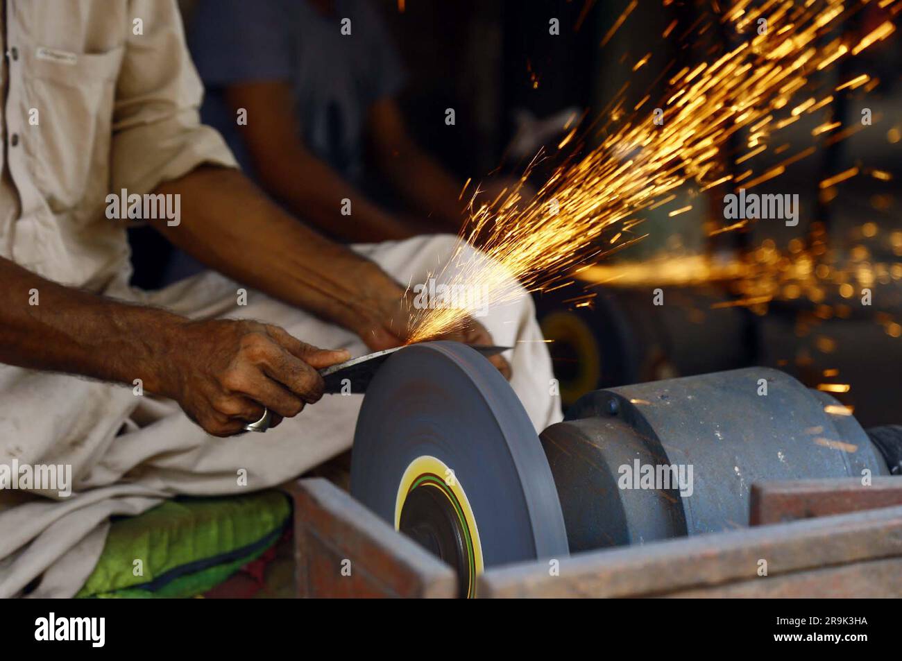 Karachi, Pakistan, June 27, 2023. Blacksmiths are busy in sharpen and ...