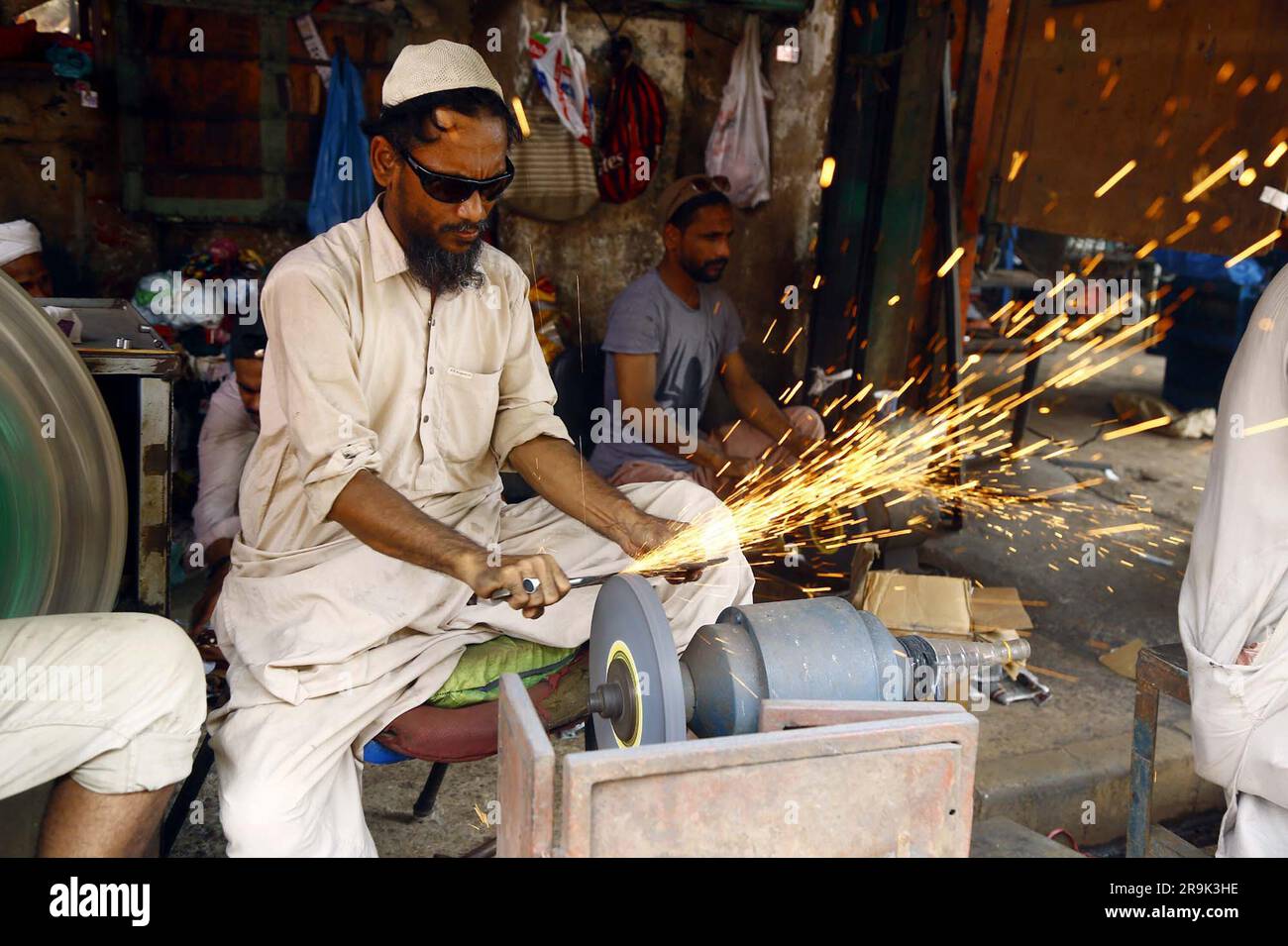 Karachi, Pakistan, June 27, 2023. Blacksmiths are busy in sharpen and ...