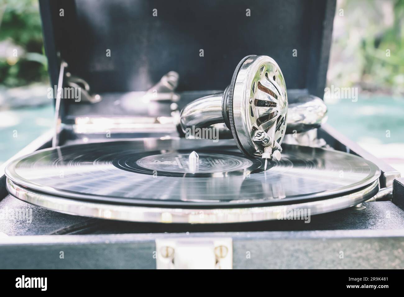 old gramophone needle player on a vinyl record. Round shiny metal needle holder head ...