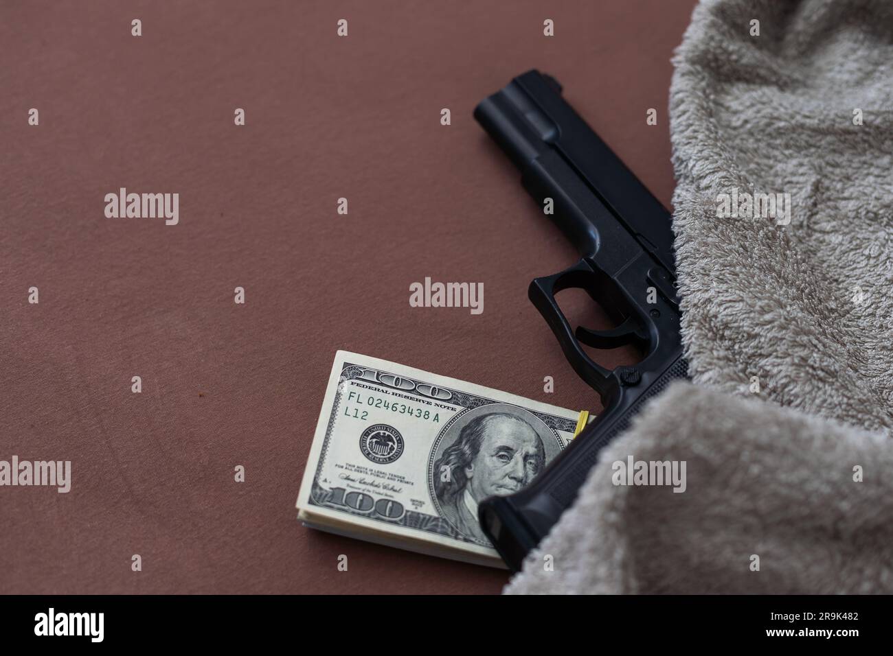 Pile of US dollar cash and a black pistol gun. Seen from above Stock ...