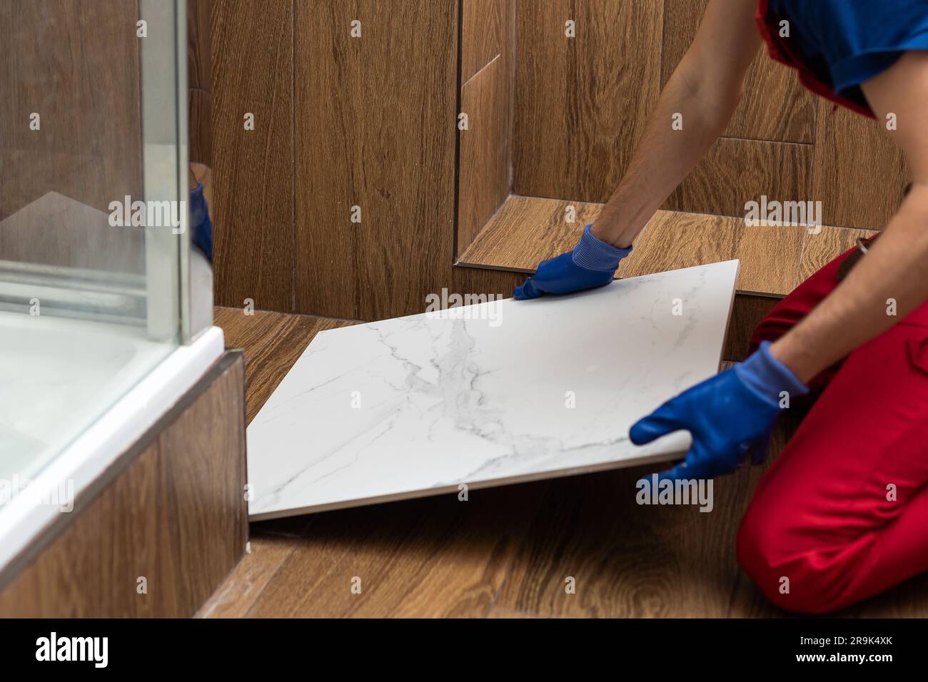 Master is wearing work clothes, is checking horizon of installing tiles ...