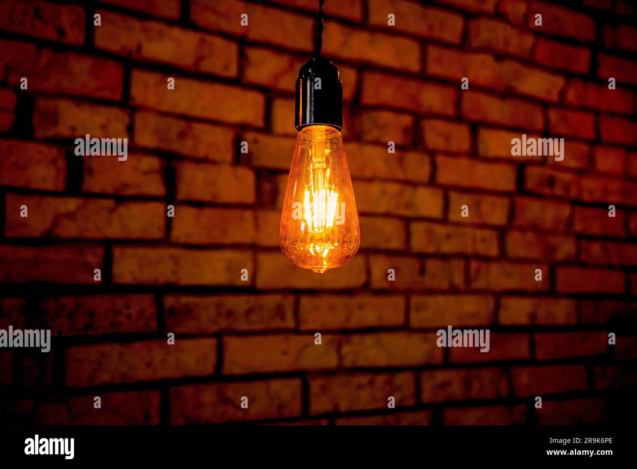 Old electric incandescent lamp with tungsten filament. Against the ...