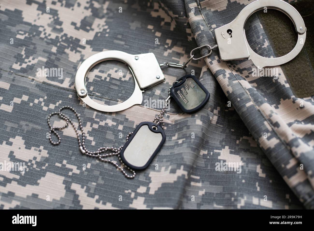 Handcuffs on a Camouflage background. Metal shackles isolated. Law ...