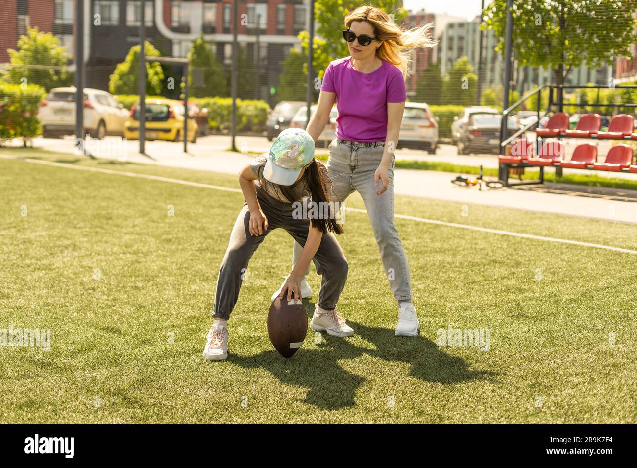 mother and daughter playing american football Stock Photo - Alamy