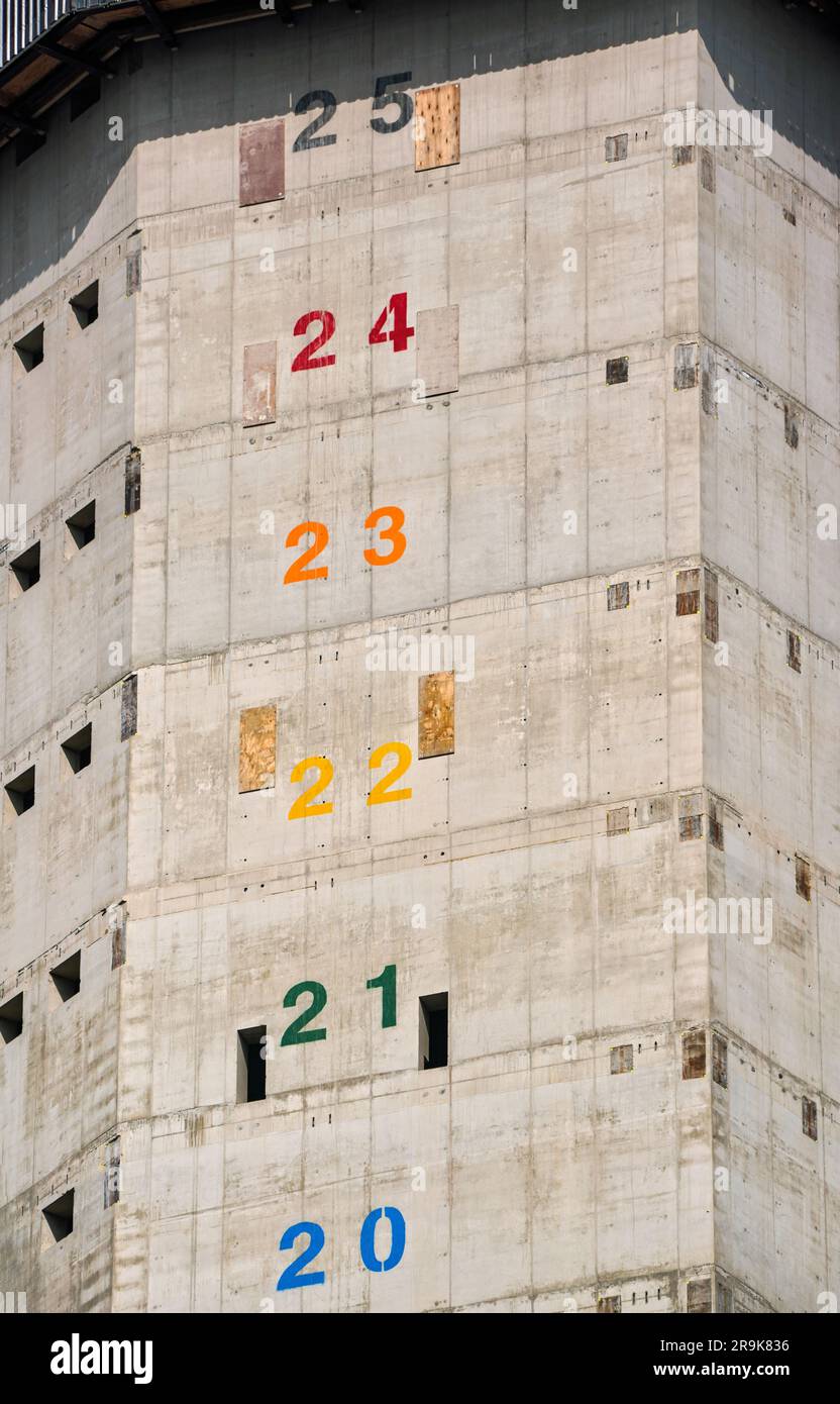 Tall modern skyscraper construction, concrete walls with numbers ...