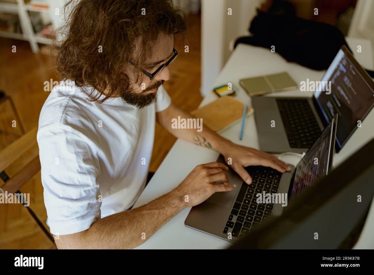 Young businessman using computer while working remotely from home ...