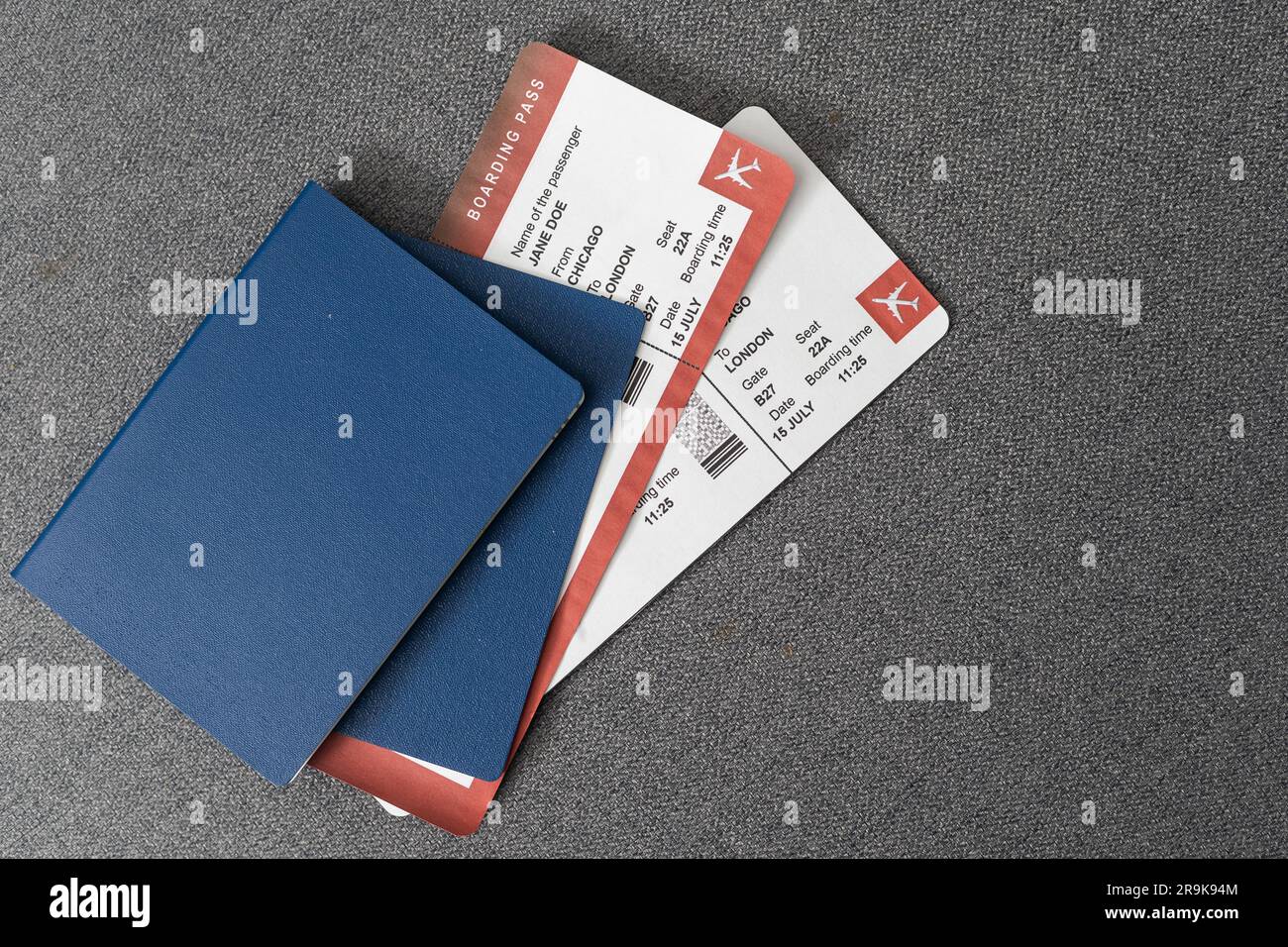 Two blue passports, green boarding pass, flight tickets gray background ...