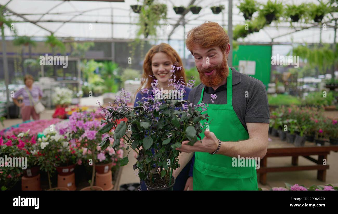 Man helping customer to select plant at Local Business Flower Shop. A ...
