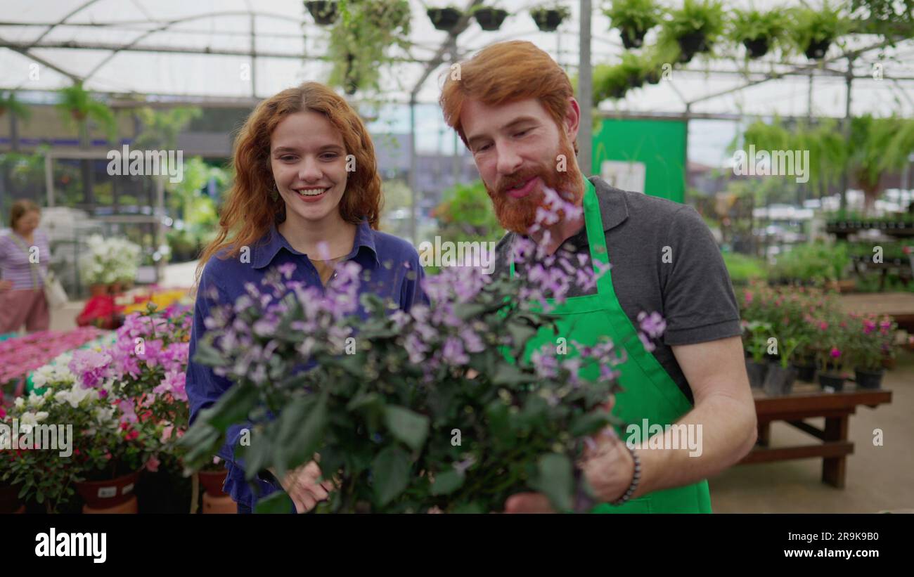 Man helping customer to select plant at Local Business Flower Shop. A ...