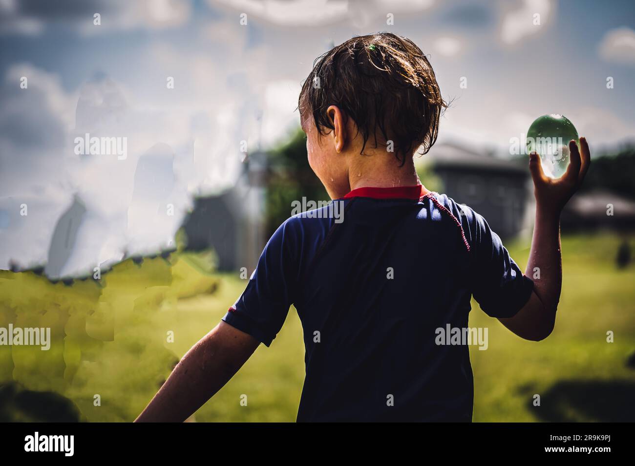 Young Caucasian boy taking aim to throw a water balloon Stock Photo - Alamy