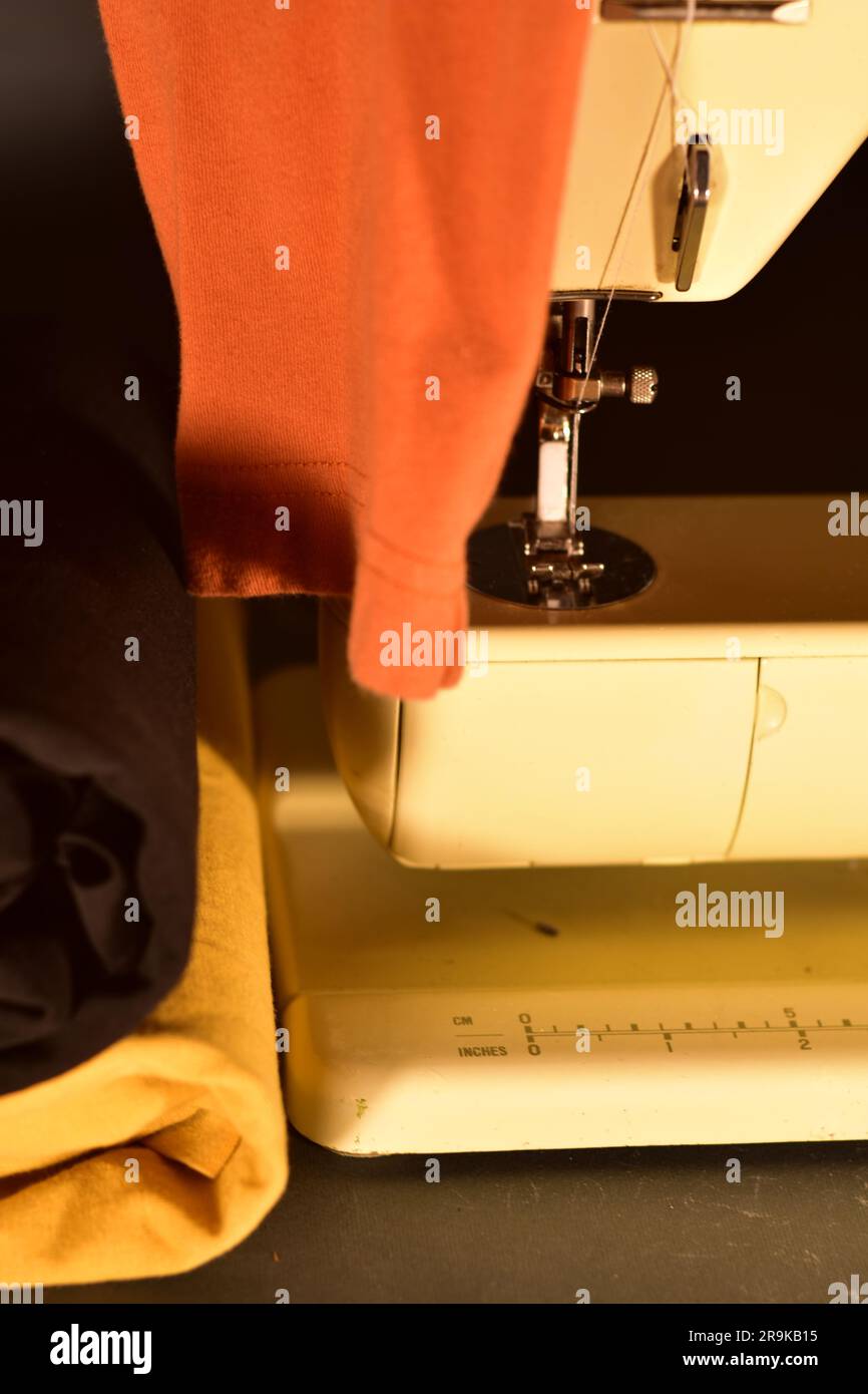 Vintage sewing machine with orange cloth on it Stock Photo - Alamy