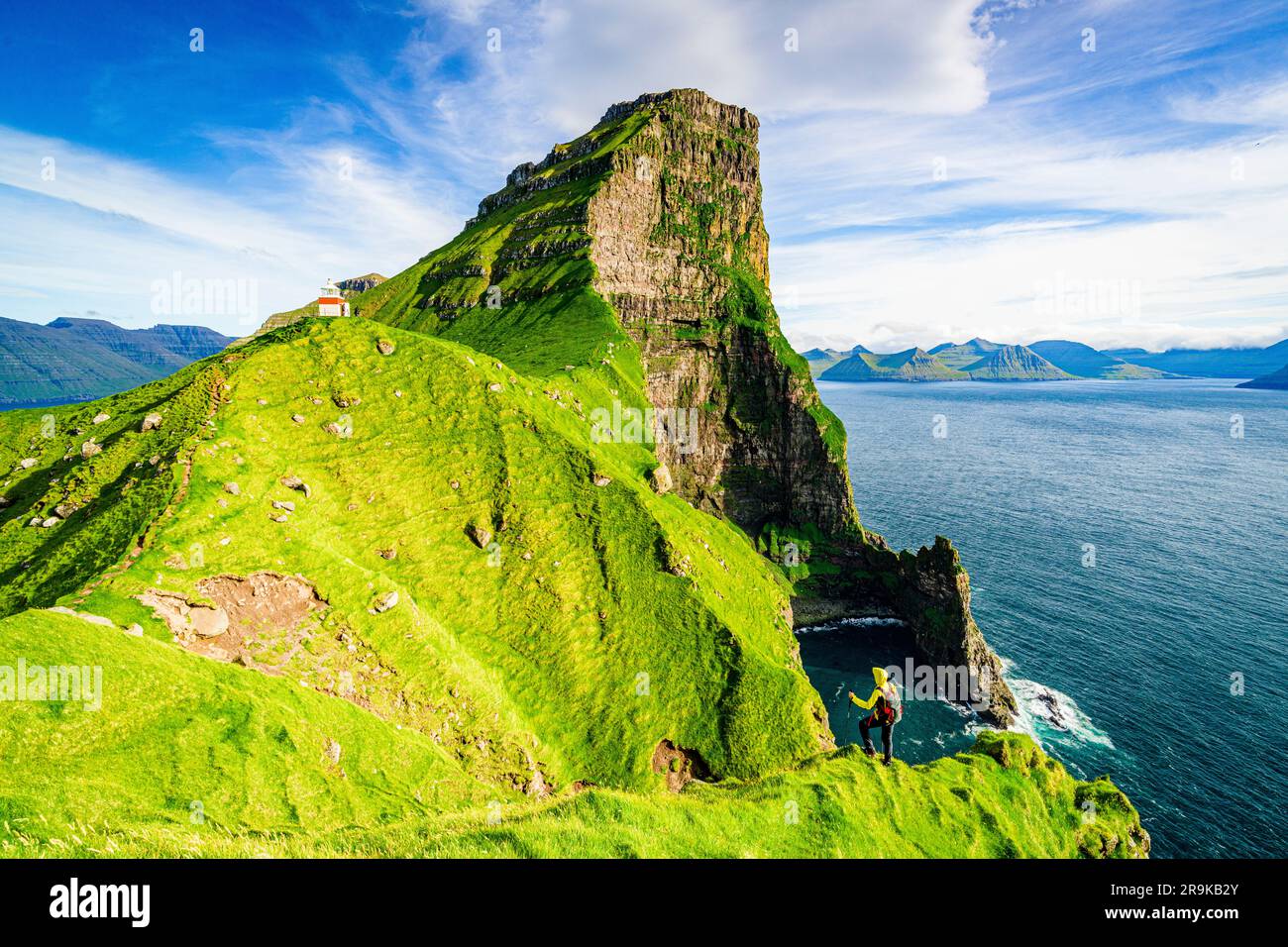 High angle view of man on cliffs admiring Kallur lighthouse overlooking ...