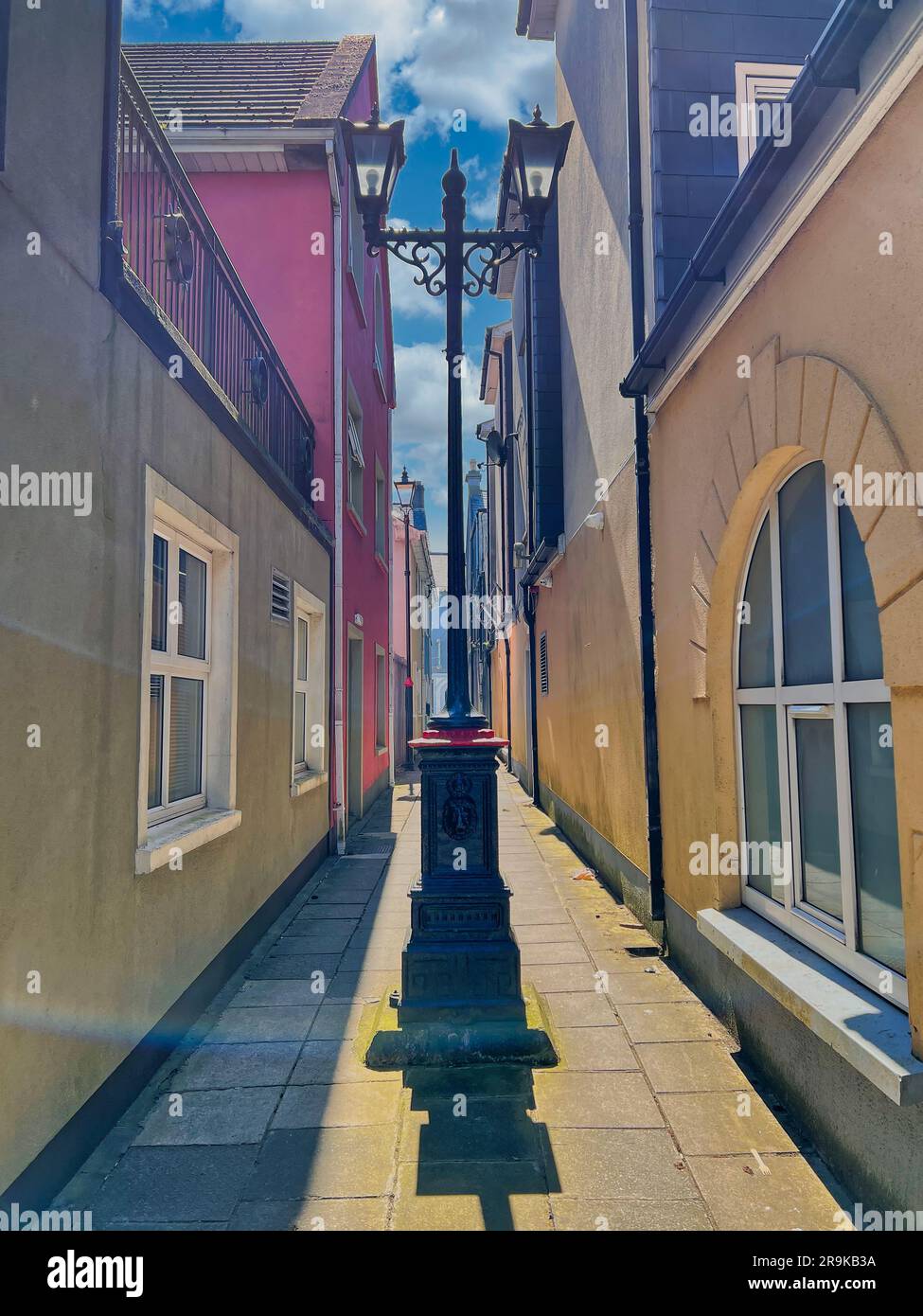 Narrow street in an Irish city. Pillar in the middle of the street ...