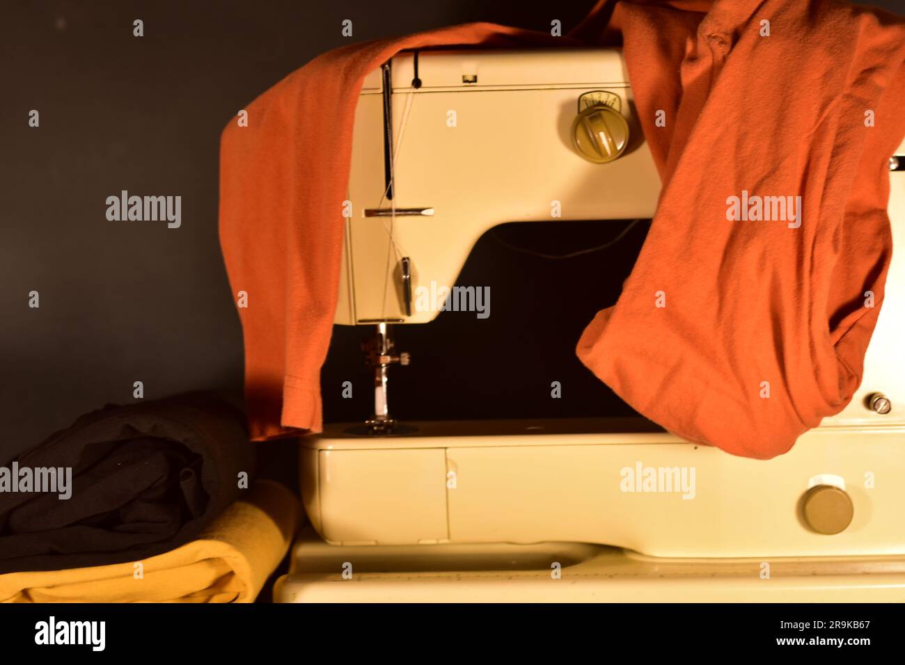 Vintage sewing machine with orange cloth on it Stock Photo - Alamy