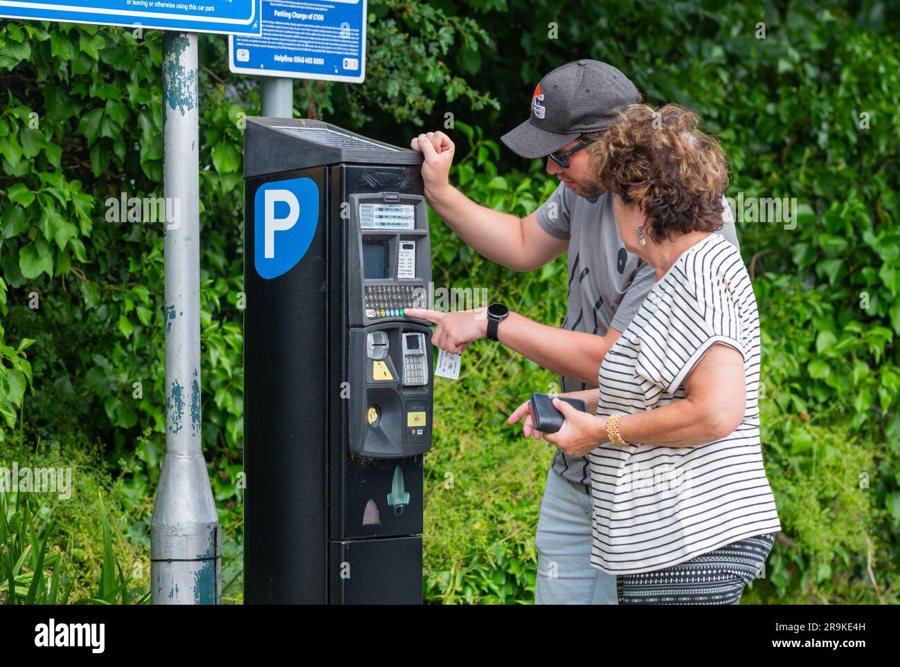 People paying for parking in a car park at a pay and display ticket ...