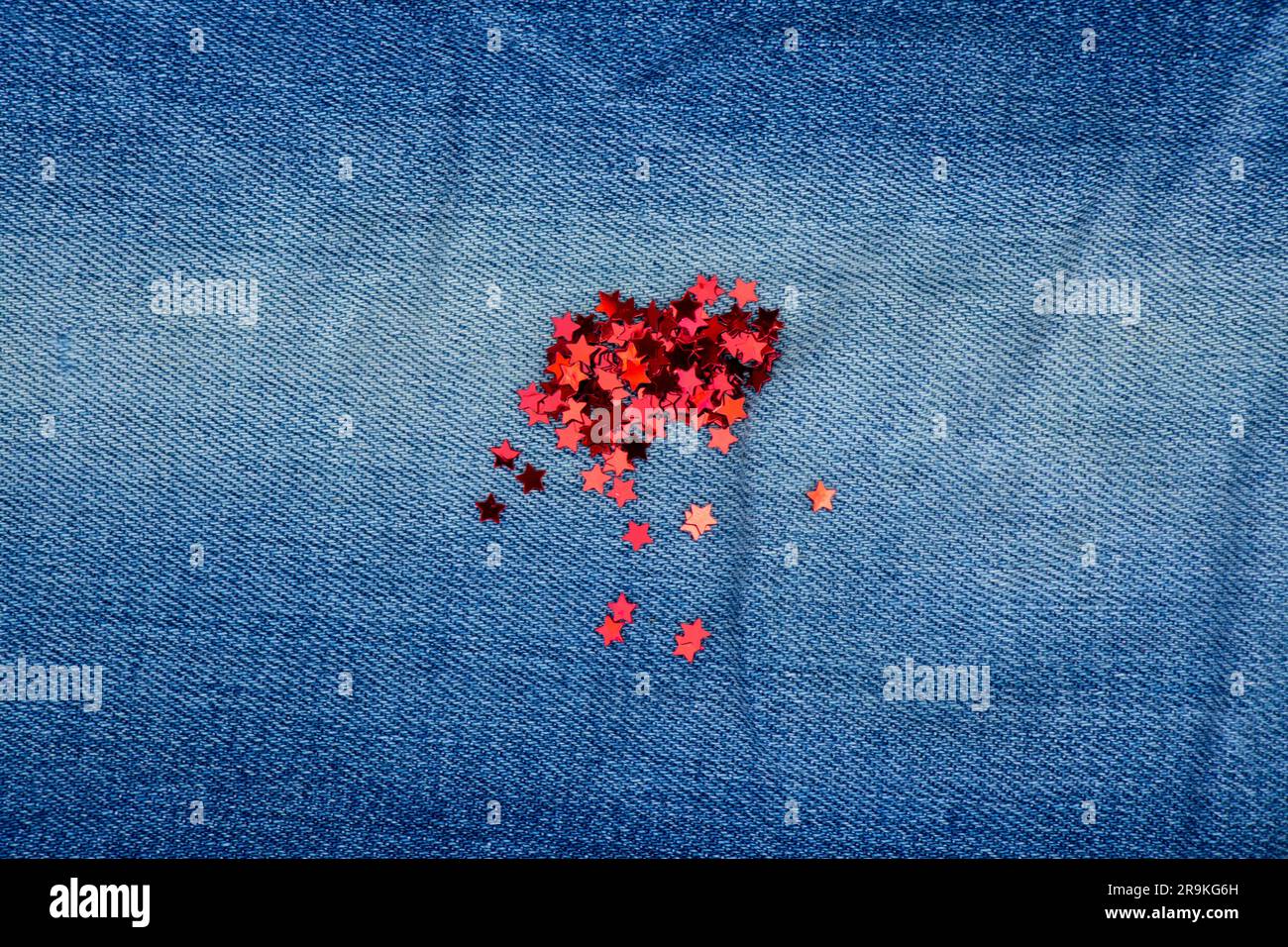 spangles red scattered on a jeans background Stock Photo - Alamy