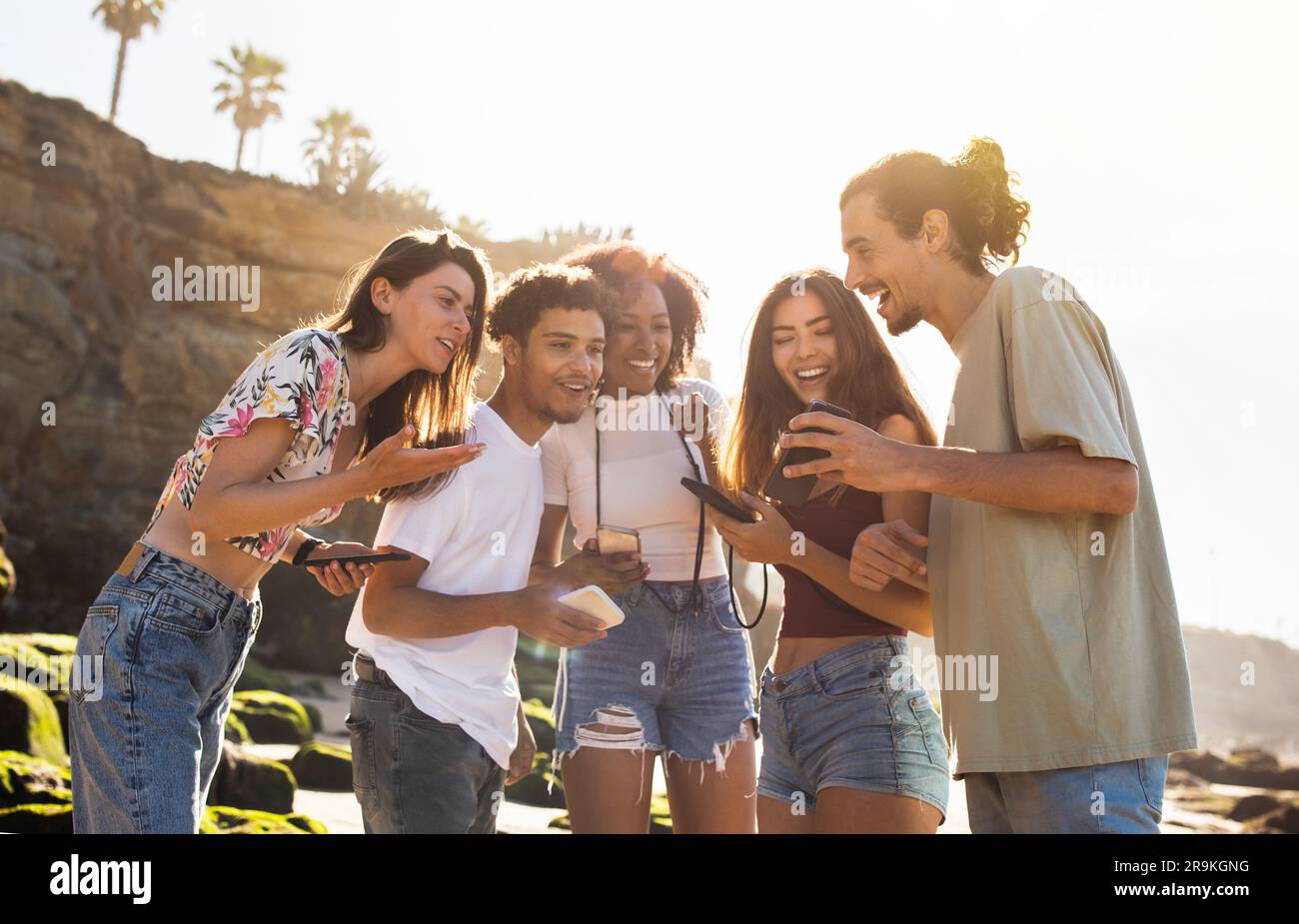 Glad millennial arab man show smartphone to friends, people student ...