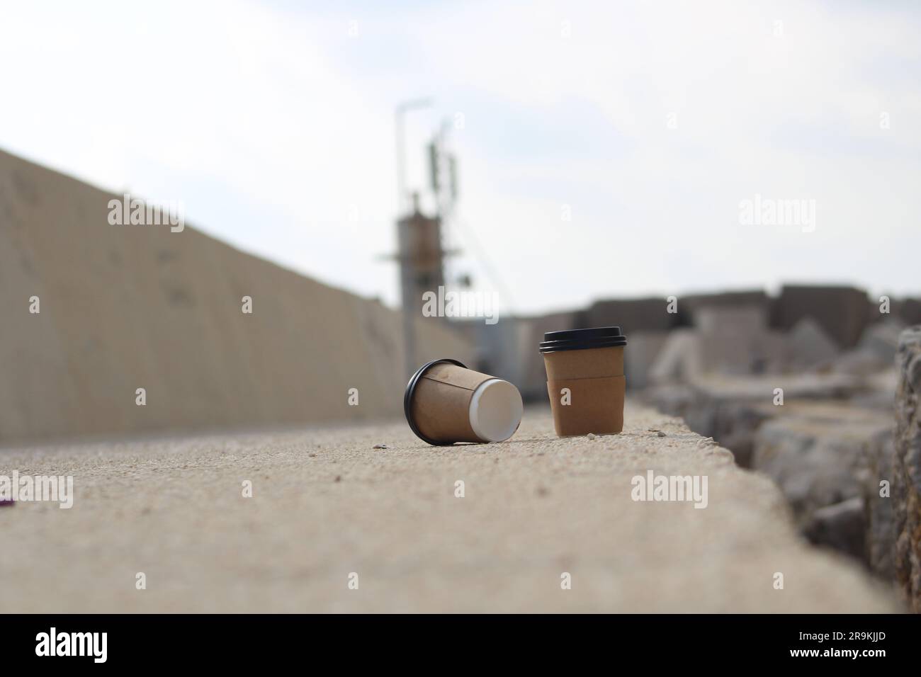 Disposable cardboard cup with plastic lid thrown on floor. Dirty coffee ...