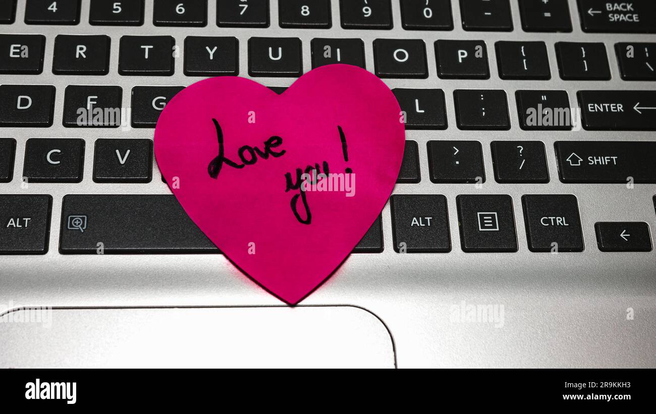 Heart shaped paper cut out on keyboard, love message and Valentine`s ...